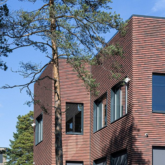 Bamble videregående skole: Røde bekledningstegler i dyp furuskog